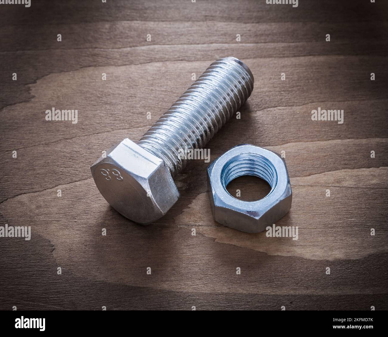 Screwbolt and screw- nut on vintage wooden board Stock Photo - Alamy
