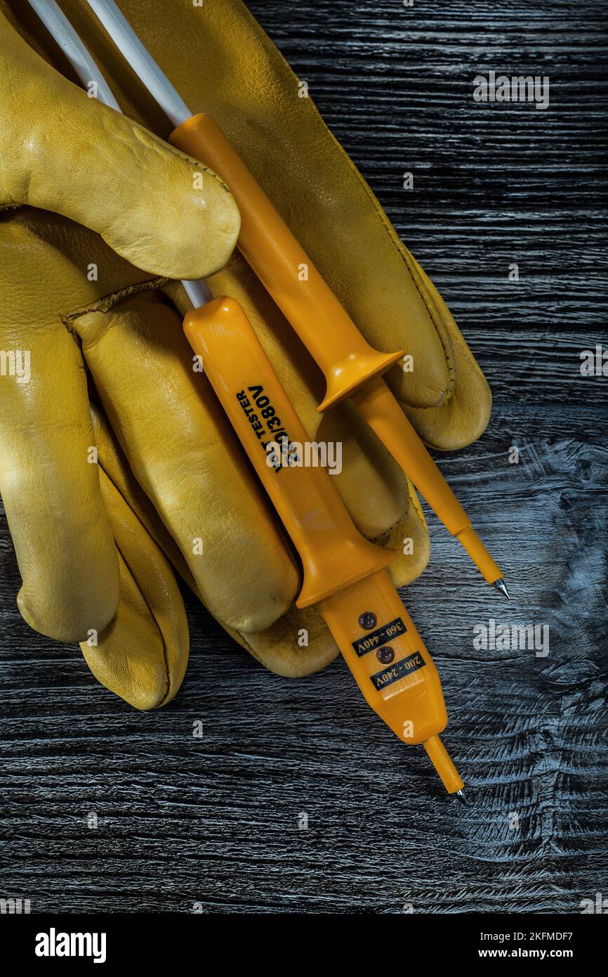 Set of electric tester safety gloves on vintage wooden board Stock ...