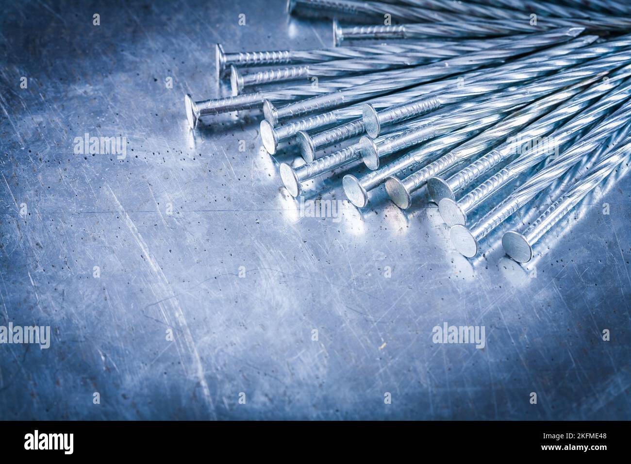 Set of stainless construction nails on scratched metallic background ...