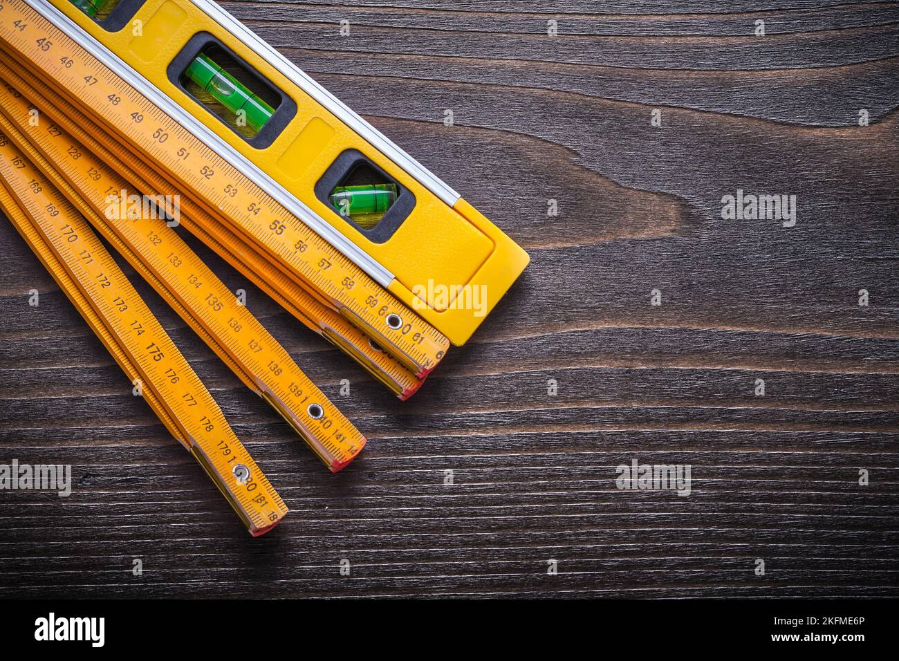 Set of yellow construction level with wooden meter on vintage wood ...