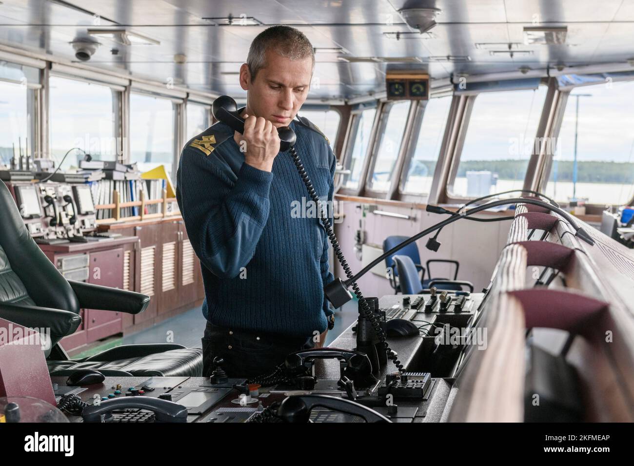 Deck officer on watch during cargo operations. Man in white overall ...