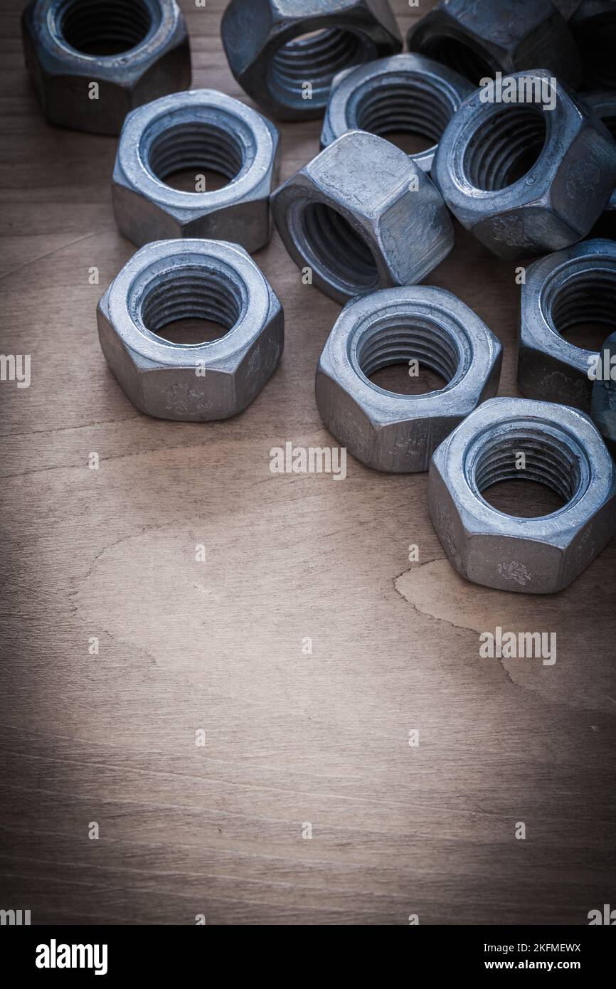 Stack of metal threaded screw-nuts on vintage wooden board Stock Photo ...