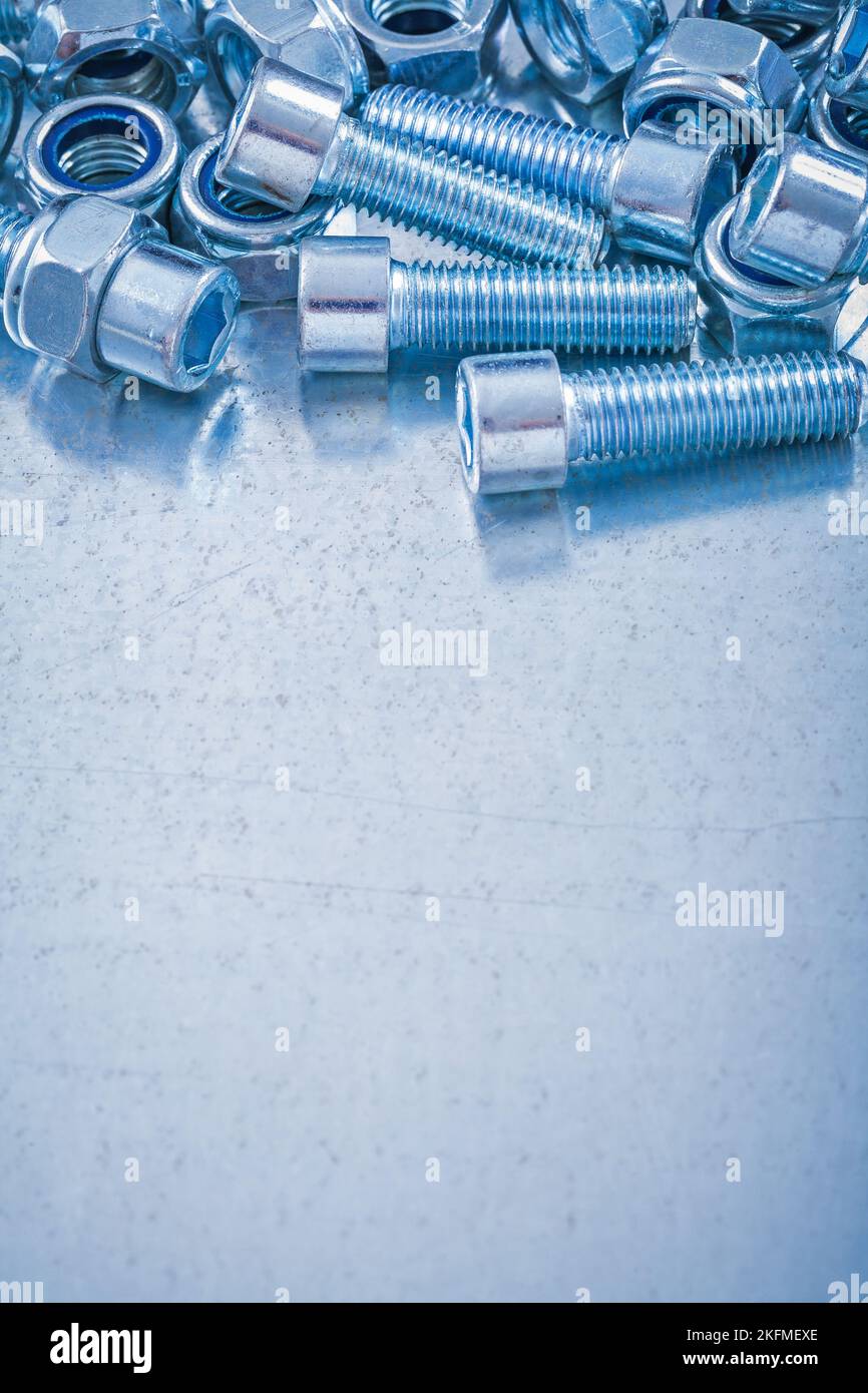 Stack of metal screw nuts and bolts on flat metallic background ...