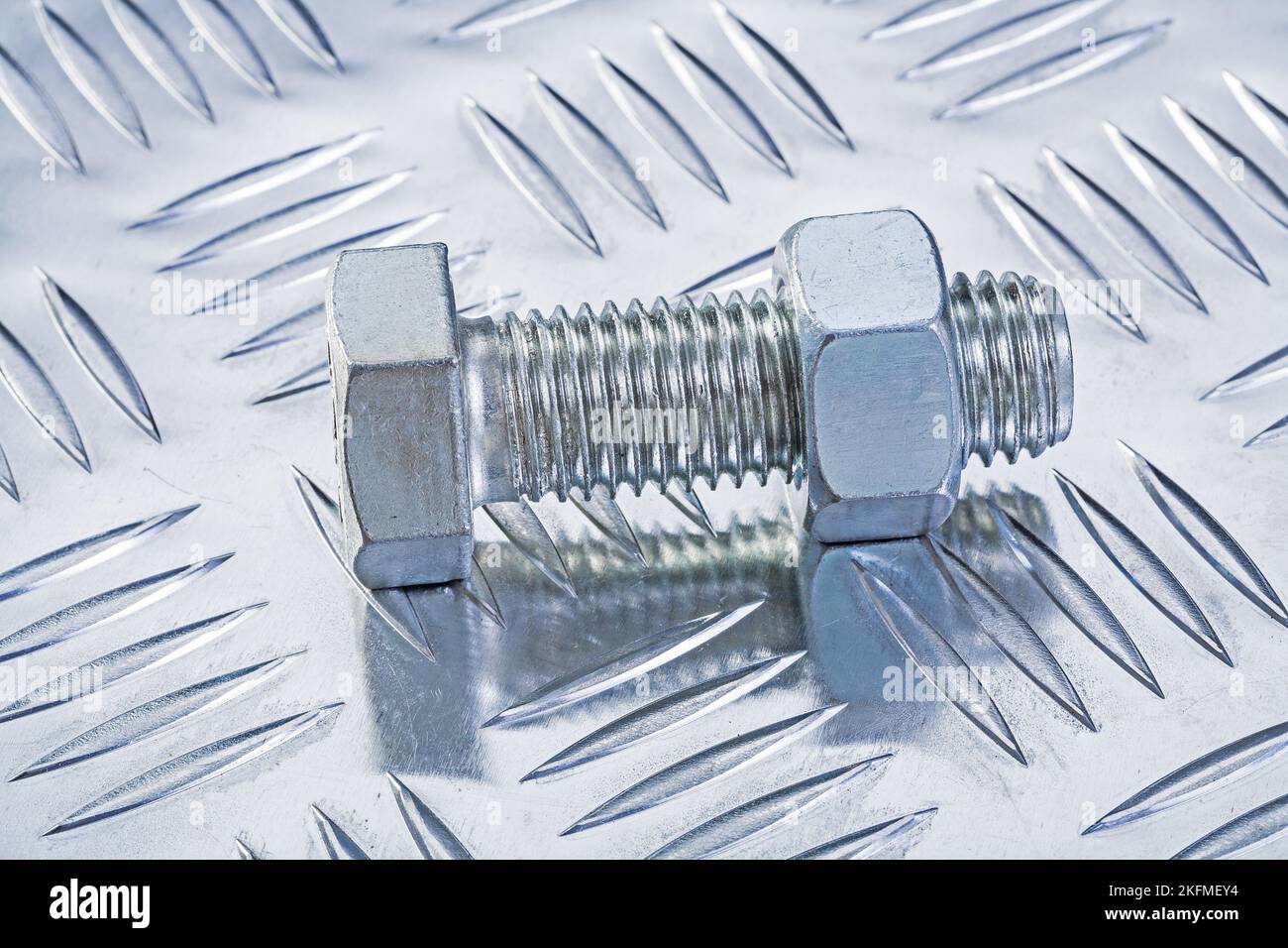 Stainless bolt and threaded nut on grooved metal plate construction ...