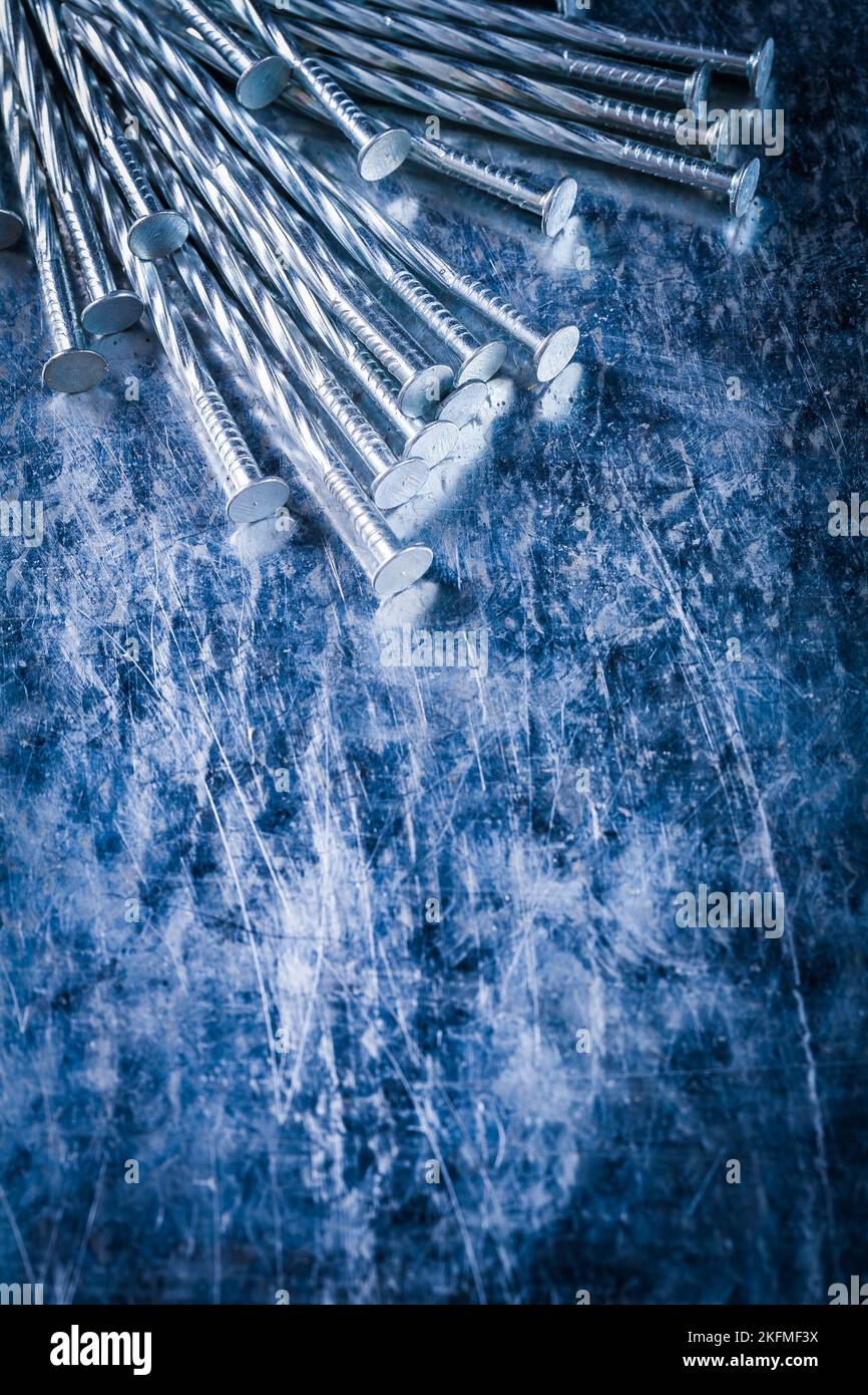 Stainless construction nails on scratched metallic background copyspace ...