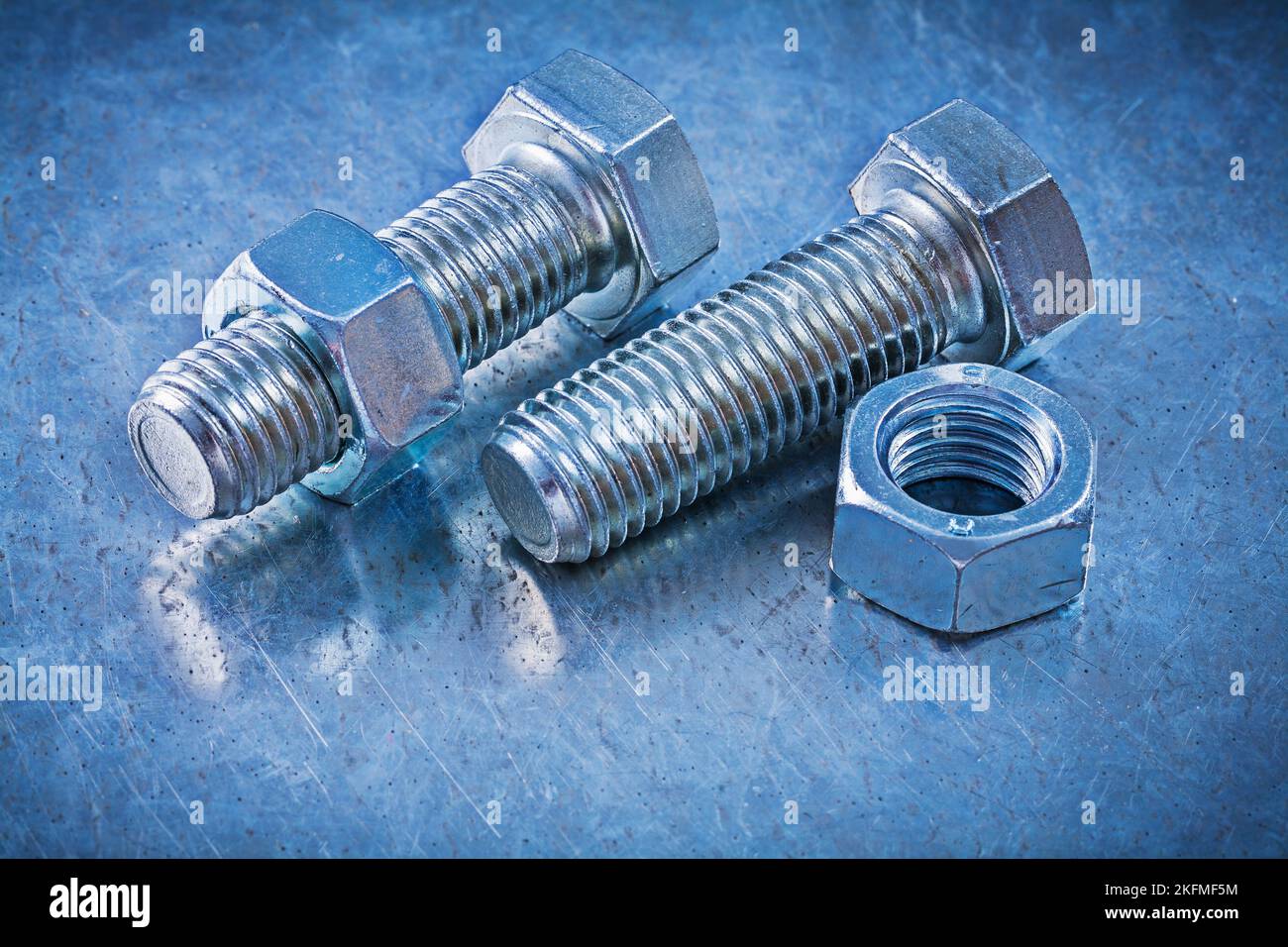 Steel bolts with screw-nuts on metallic background construction concept ...