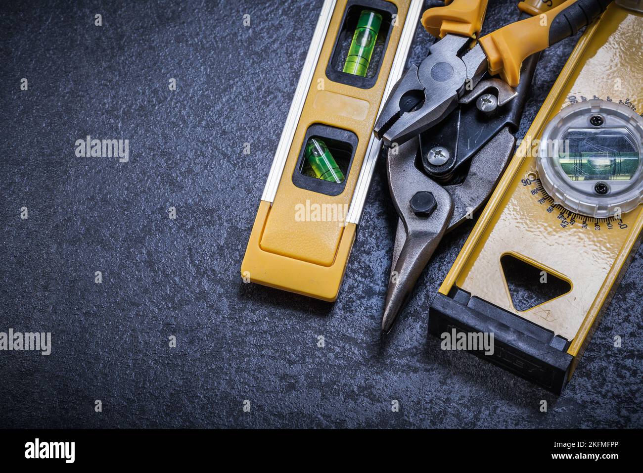 Tin snips pliers construction level on black background Stock Photo - Alamy