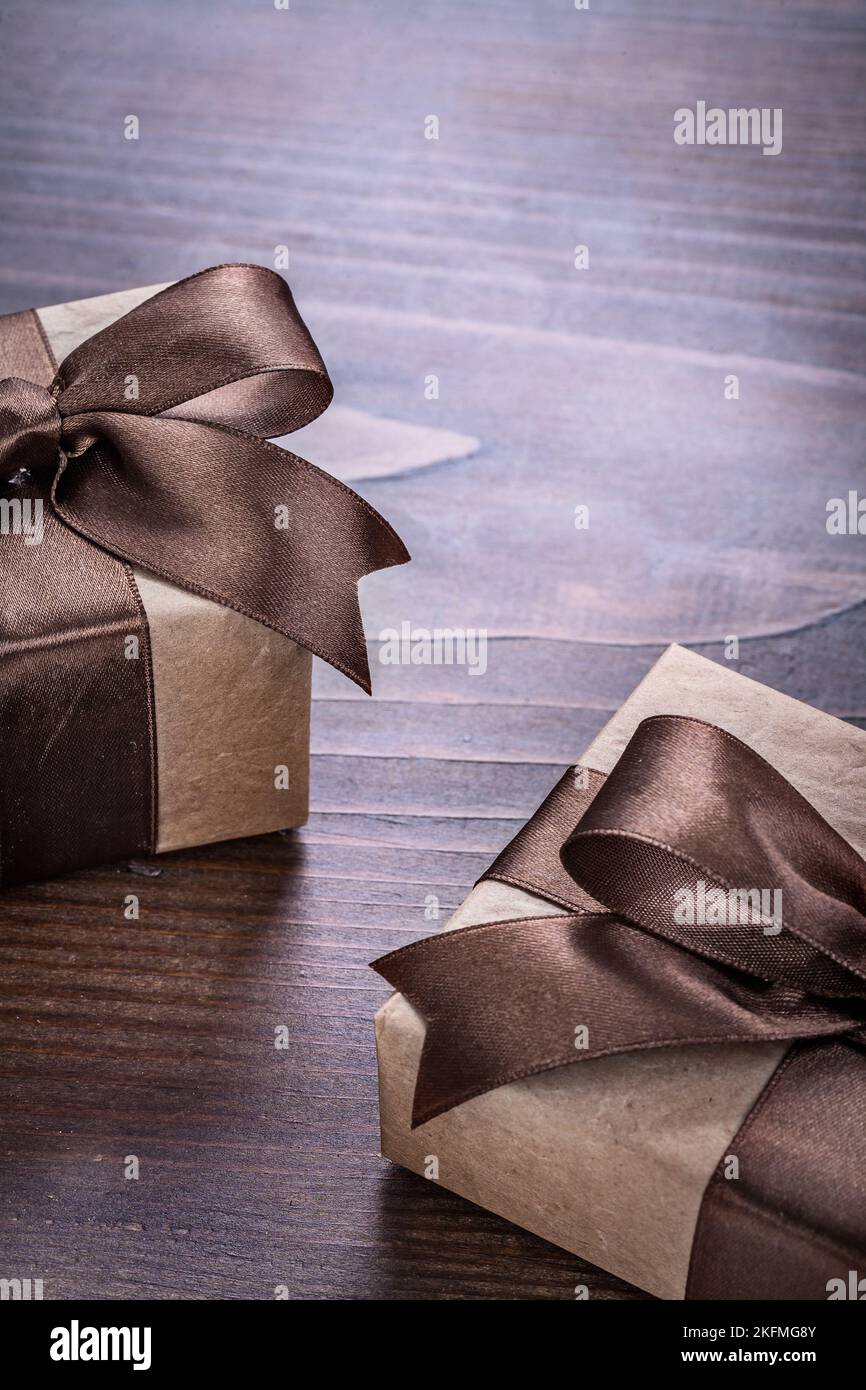 two vintage gift boxes with brown ribbons on old wooden board holiday ...