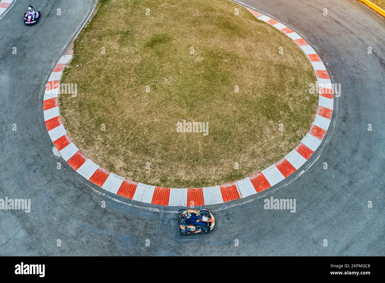 Aerial top view of the go-kart track from the drone. Kart racers drive ...