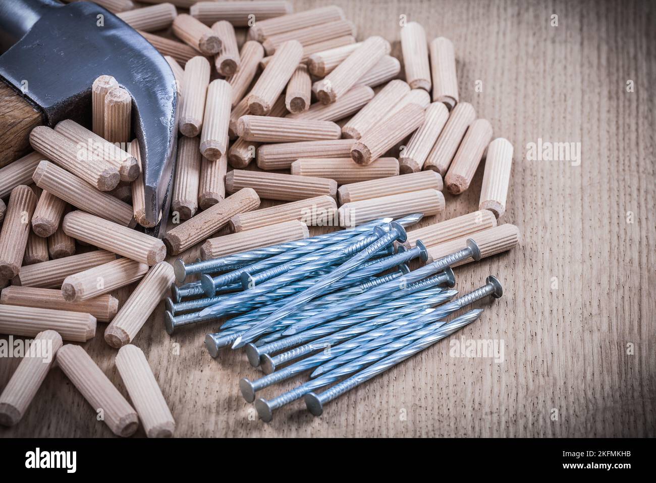 Wooden dowel pins nails claw hammer on textured wood board Stock Photo ...