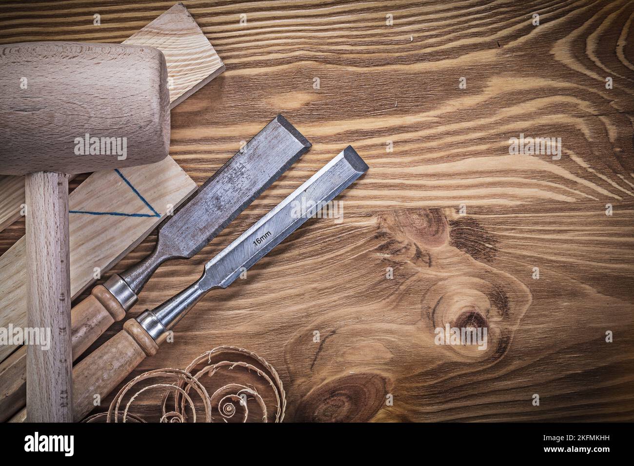 Wooden hammer bricks flat chisels planning chips on vintage wood board ...