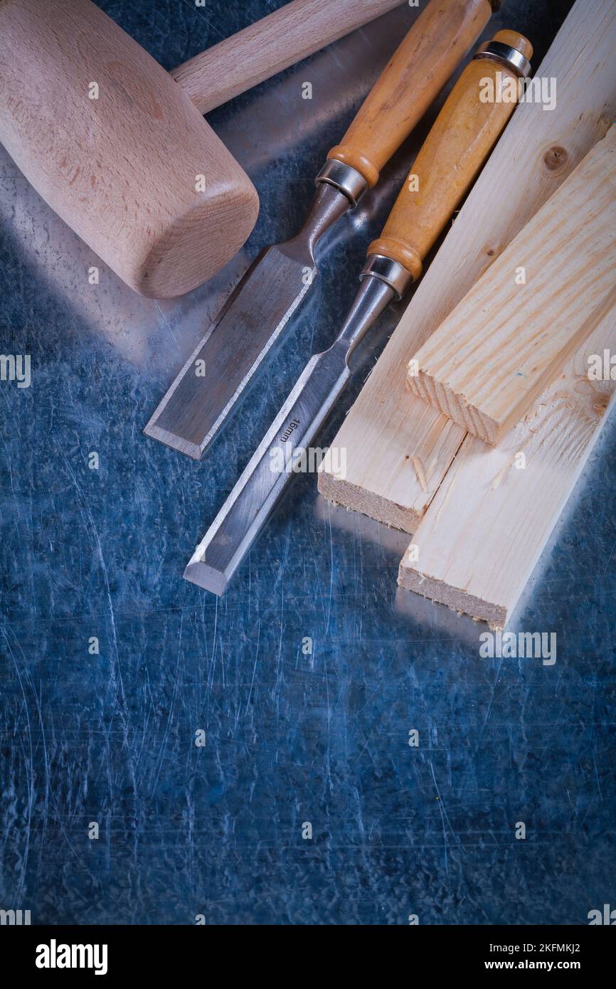 Wooden hammer studs and firmer chisels on scratched metallic background ...