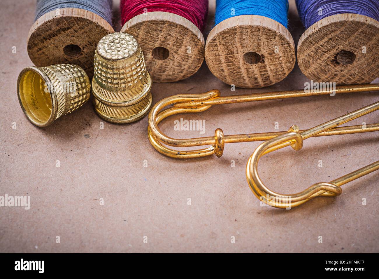 Wooden spools of threads thimbles clasp pins on vintage background ...