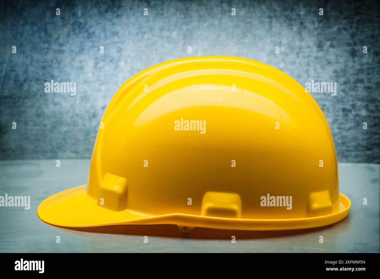 yellow construction helmet on metalic background close up side view ...