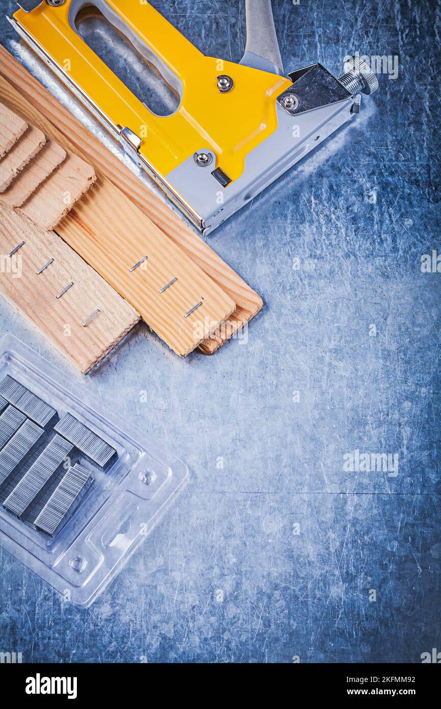 Yellow construction stapler chrome staples wooden building board on ...