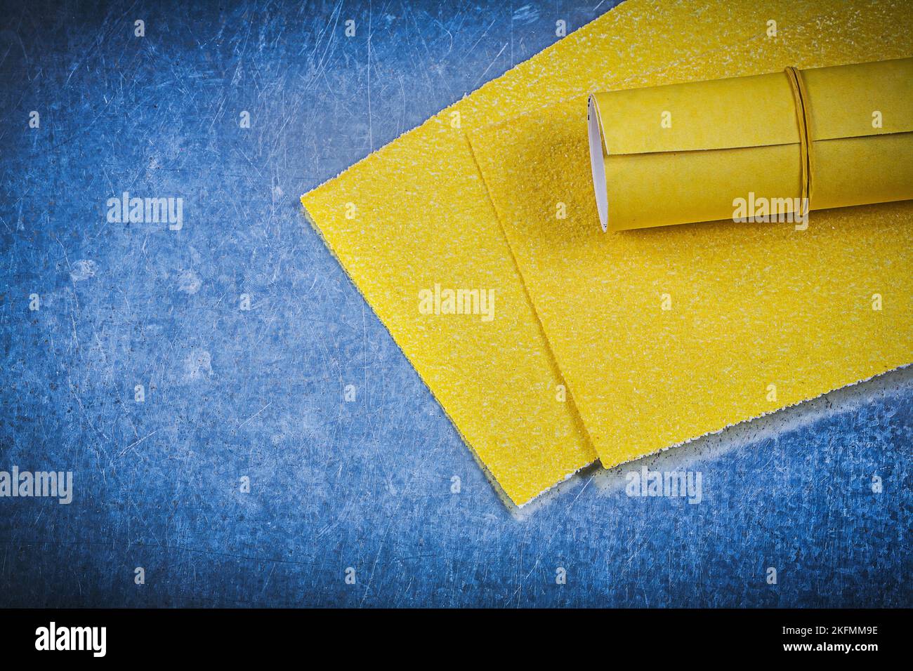 Yellow emery paper on metallic background Stock Photo - Alamy