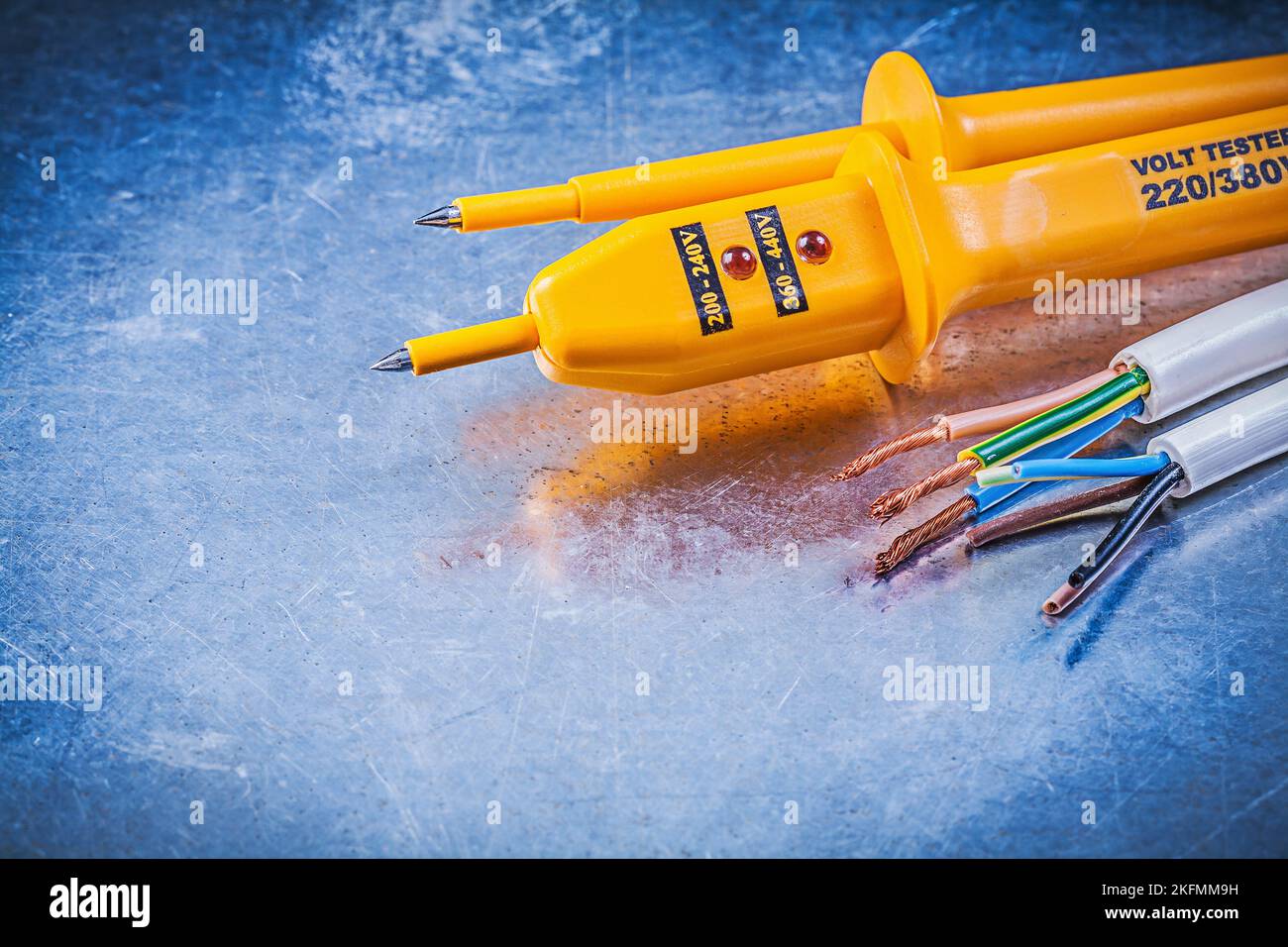 Yellow electrical tester wires on metallic background electricity ...