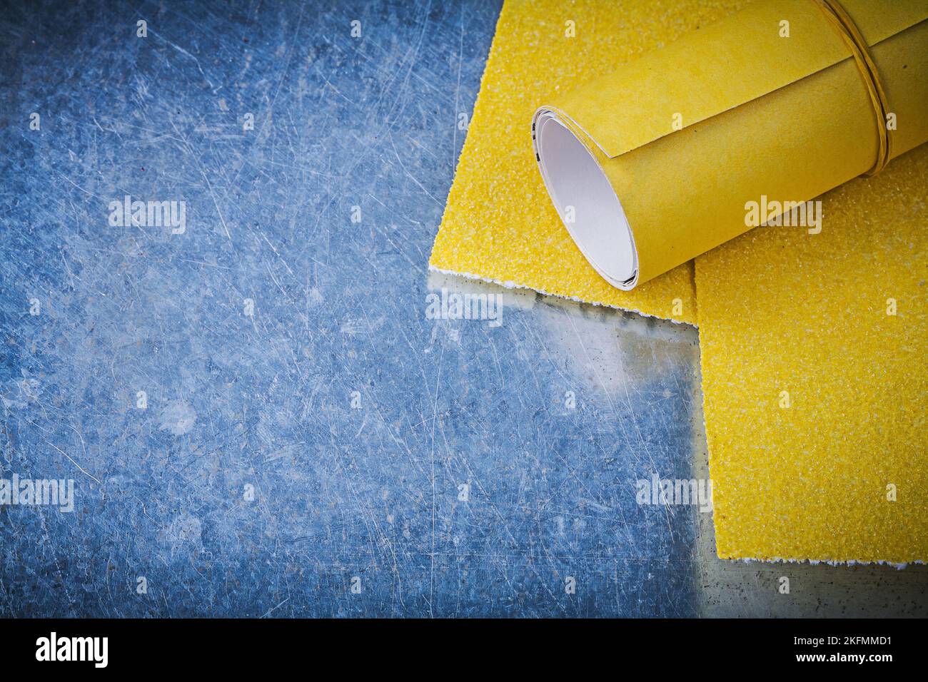 Yellow sandpaper on scratched metallic background abrasive materials ...
