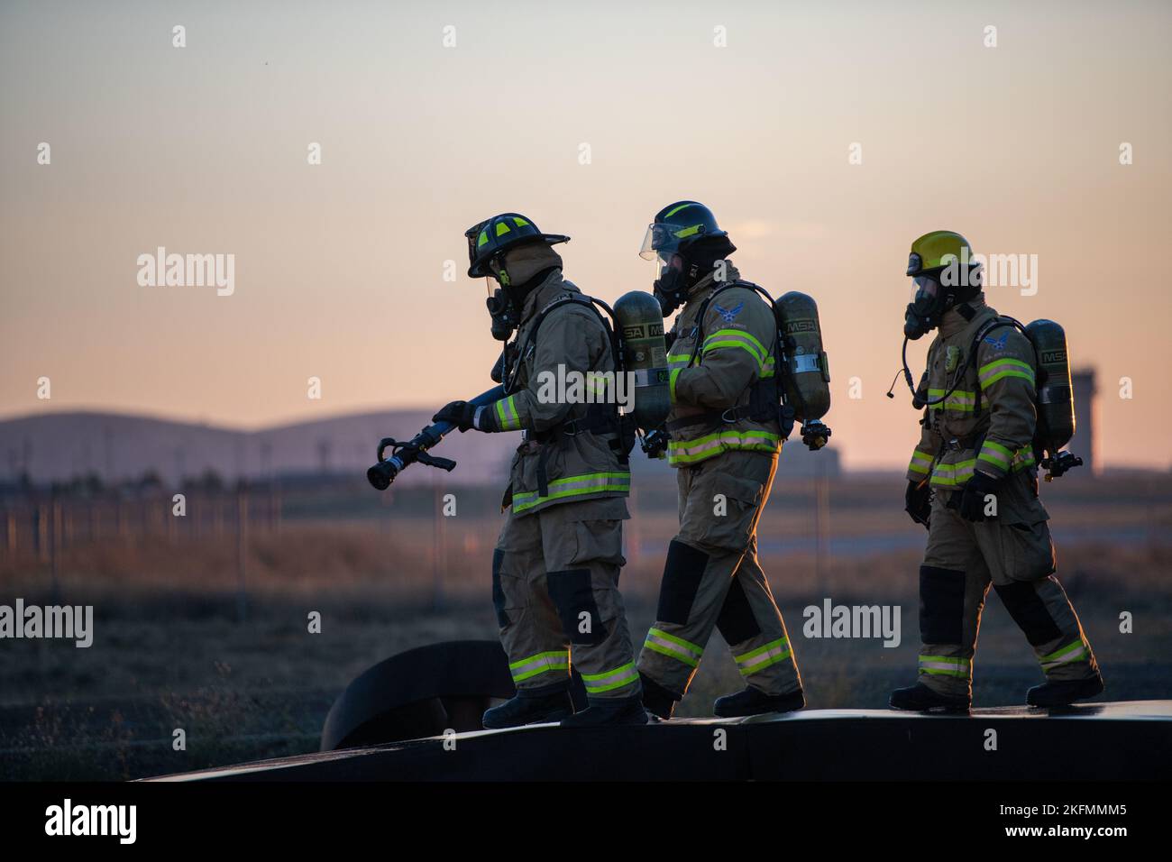 Firefighters from the 92nd Civil Engineer Squadron carry a water hose ...