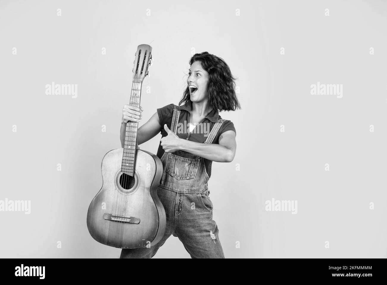 Brunette girl playing guitar Black and White Stock Photos & Images - Alamy