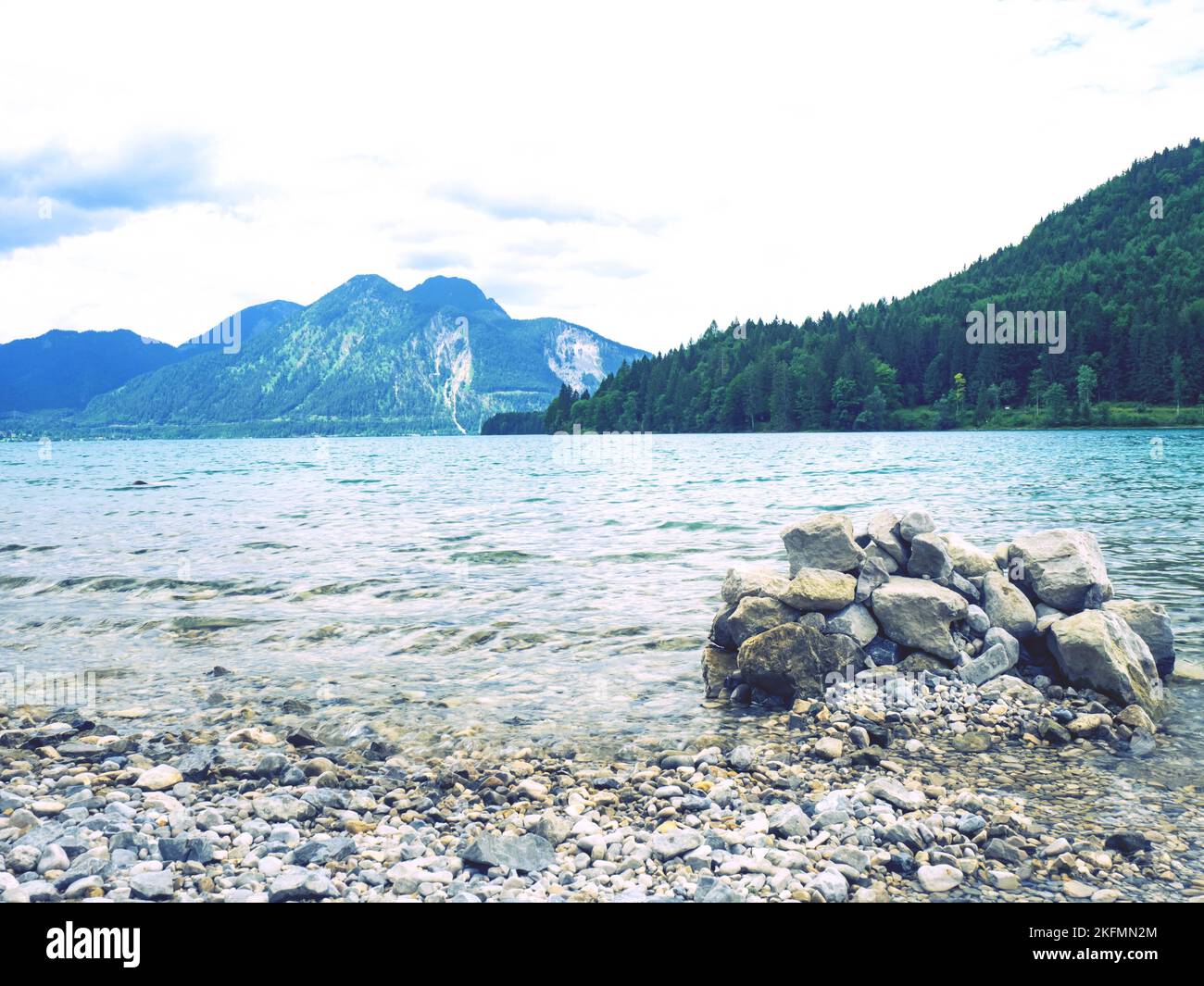 Balanced stones stacked in pyramid at lake water with Dolomite Alps ...