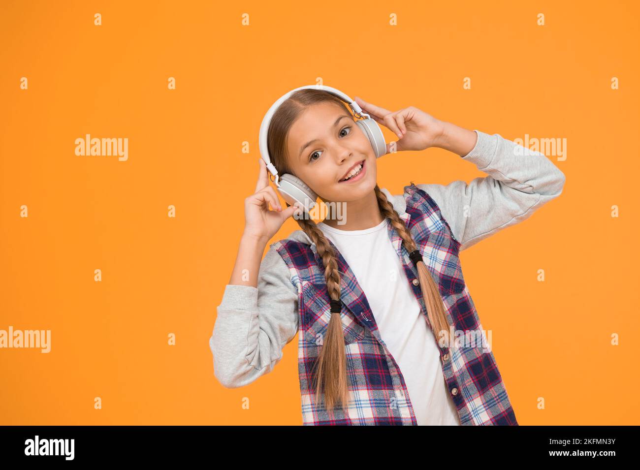 Happy little girl wearing modern headphones. Cute kid enjoying stereo ...
