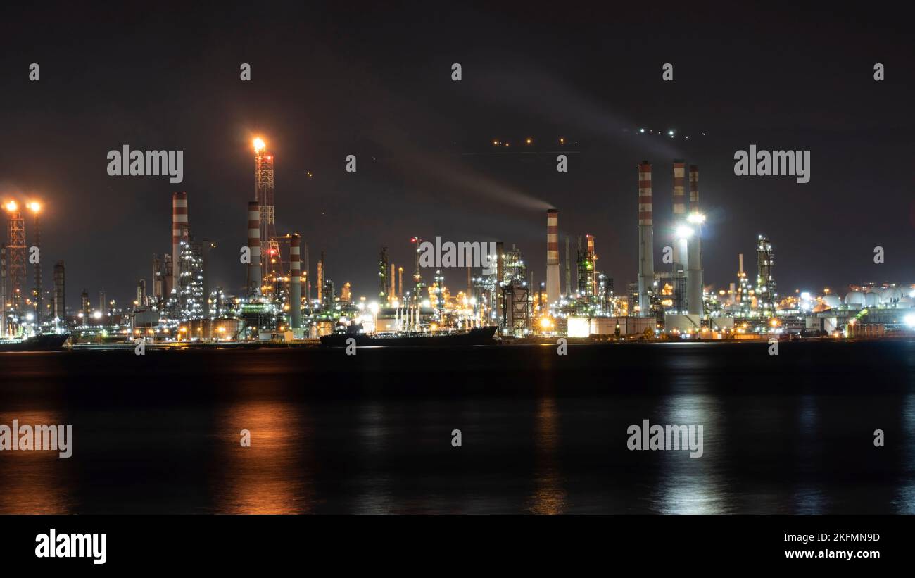 Oil refinery plant at night. Long exposure of factory lights reflection ...