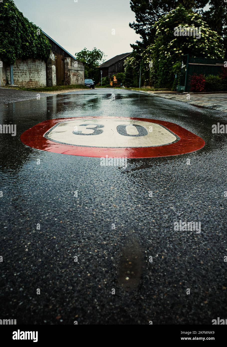 A vertical shot of a large sign painted on the rain-wetted ground ...