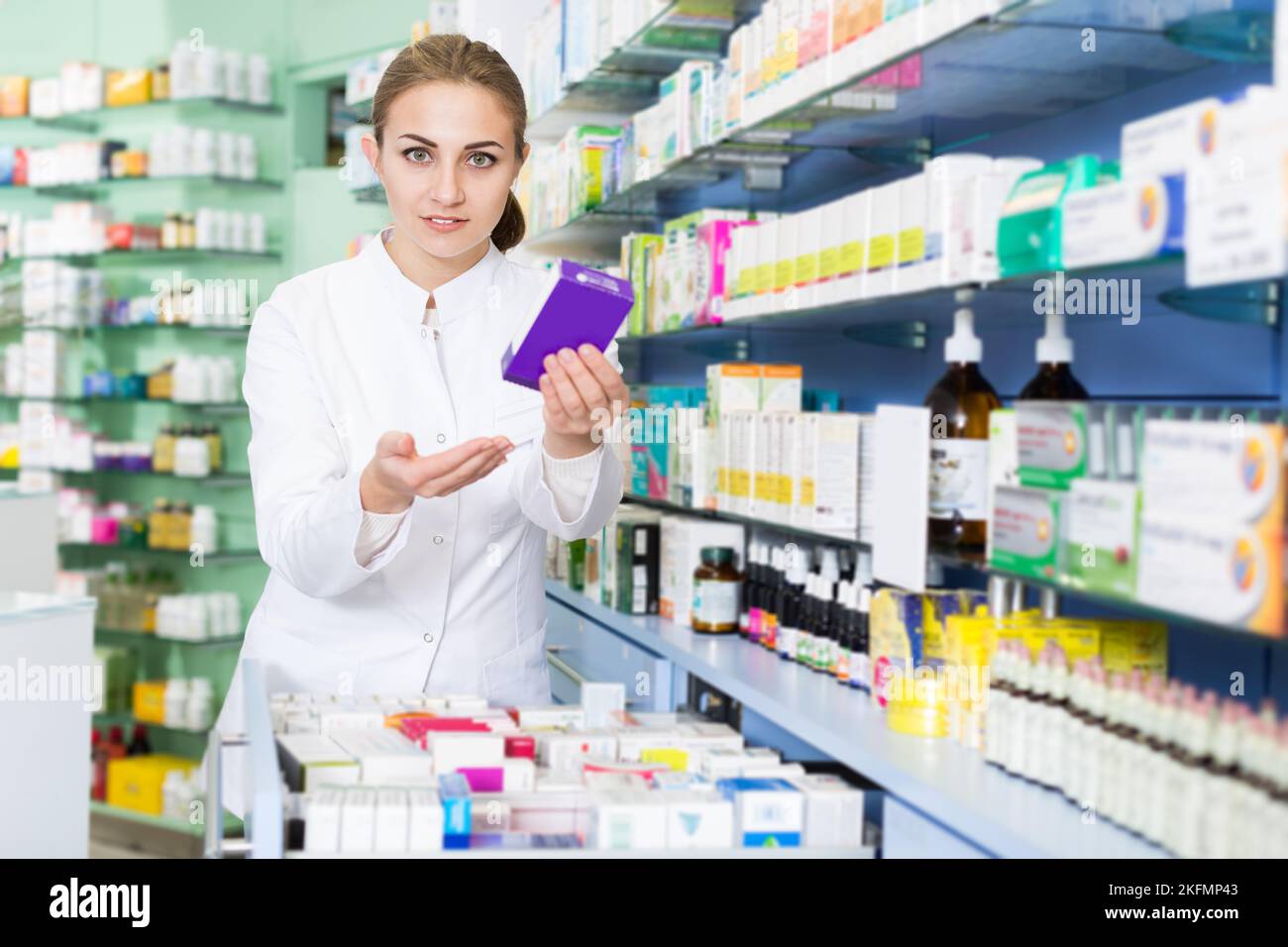 Portrait of positive female pharmacist is sshowing medicines Stock ...