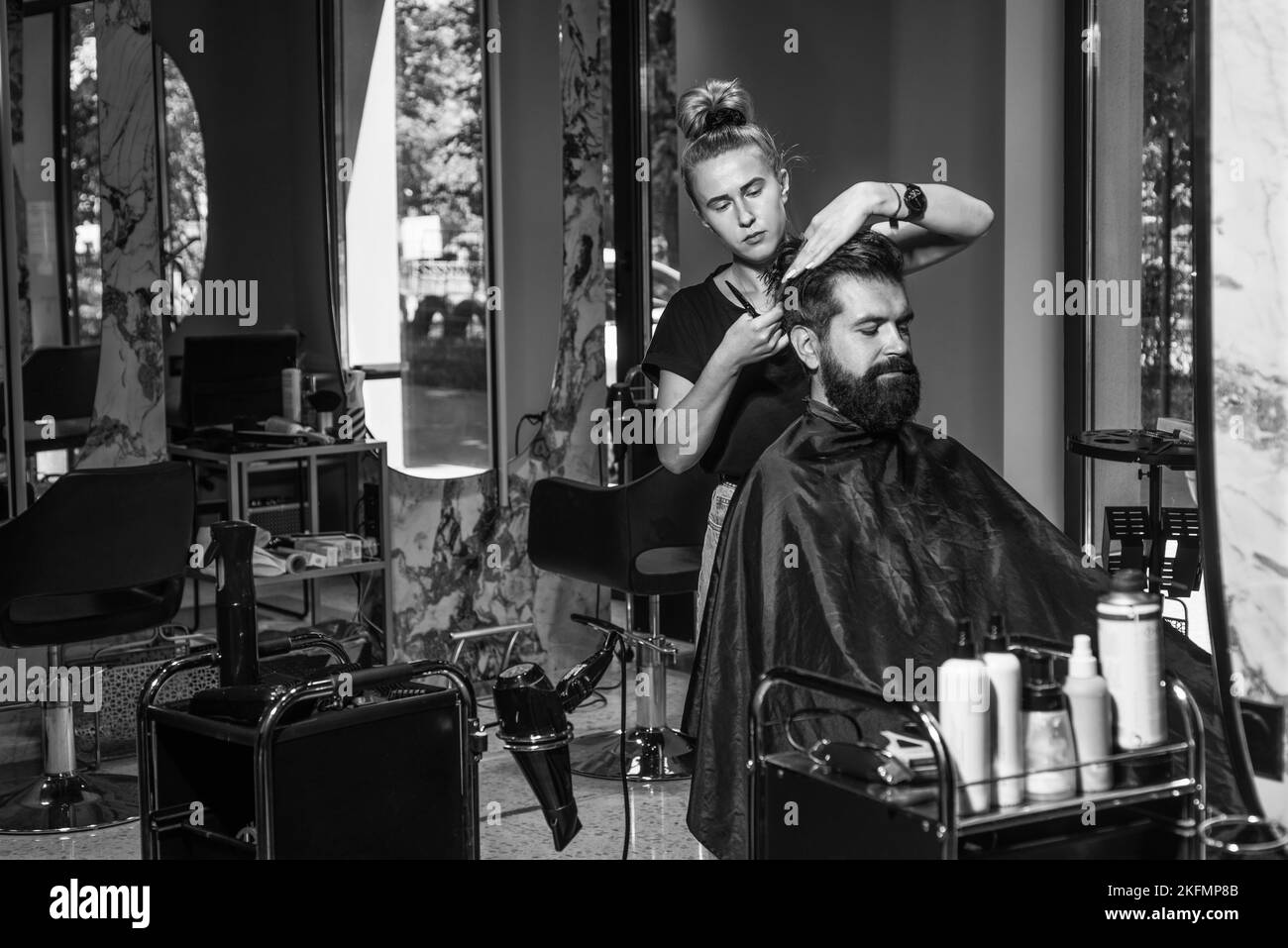 Portrait of stylish guy and Barber master with scissors and brush ...