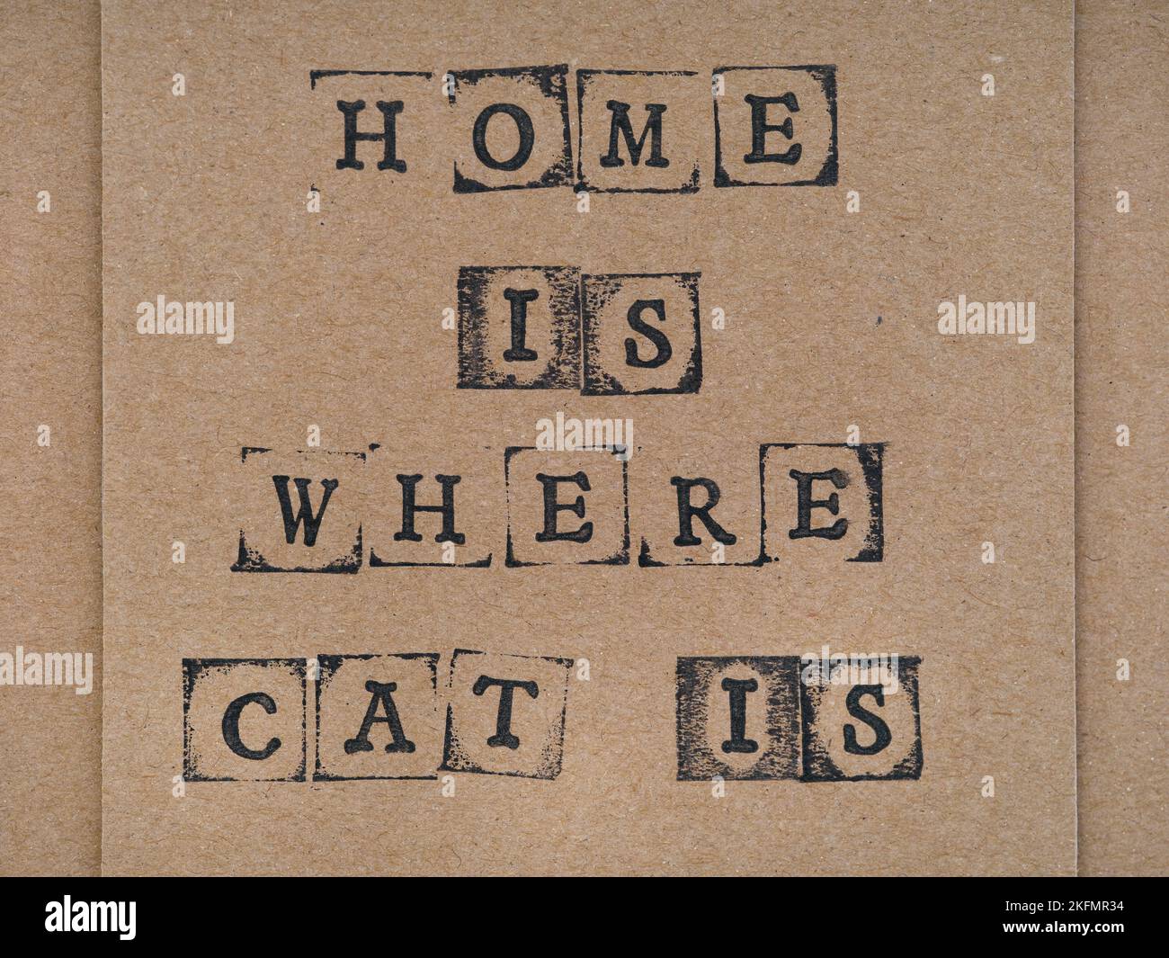A cardboard with words Home Is Where Cat Is made by black alphabet ...