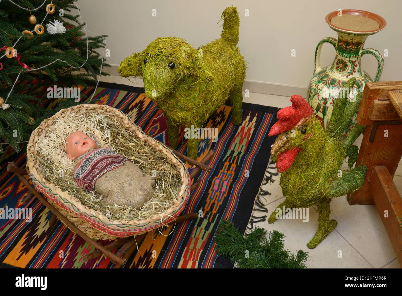 Santa gifts made of straw toys doll in a cradle, sheep and rooster ...