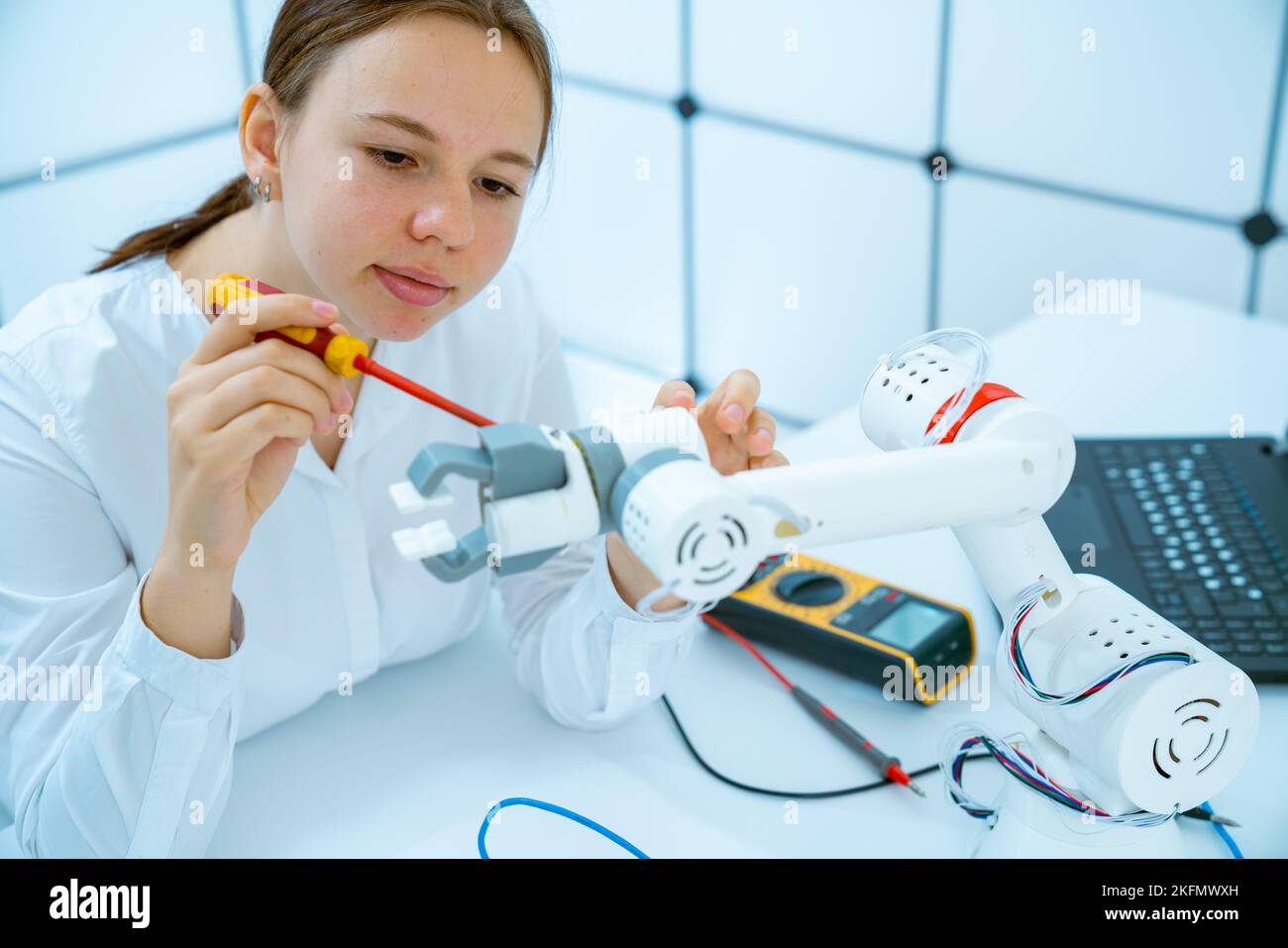 assembling a model of an industrial robot in the university laboratory a young woman with a ...