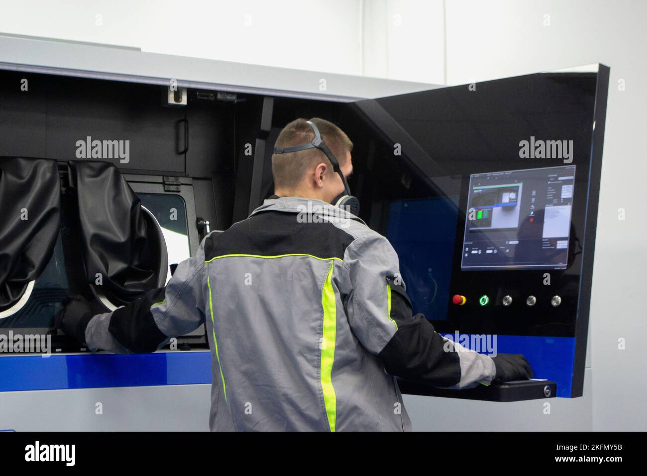The worker controls workflow inside large industrial 3D printer ...