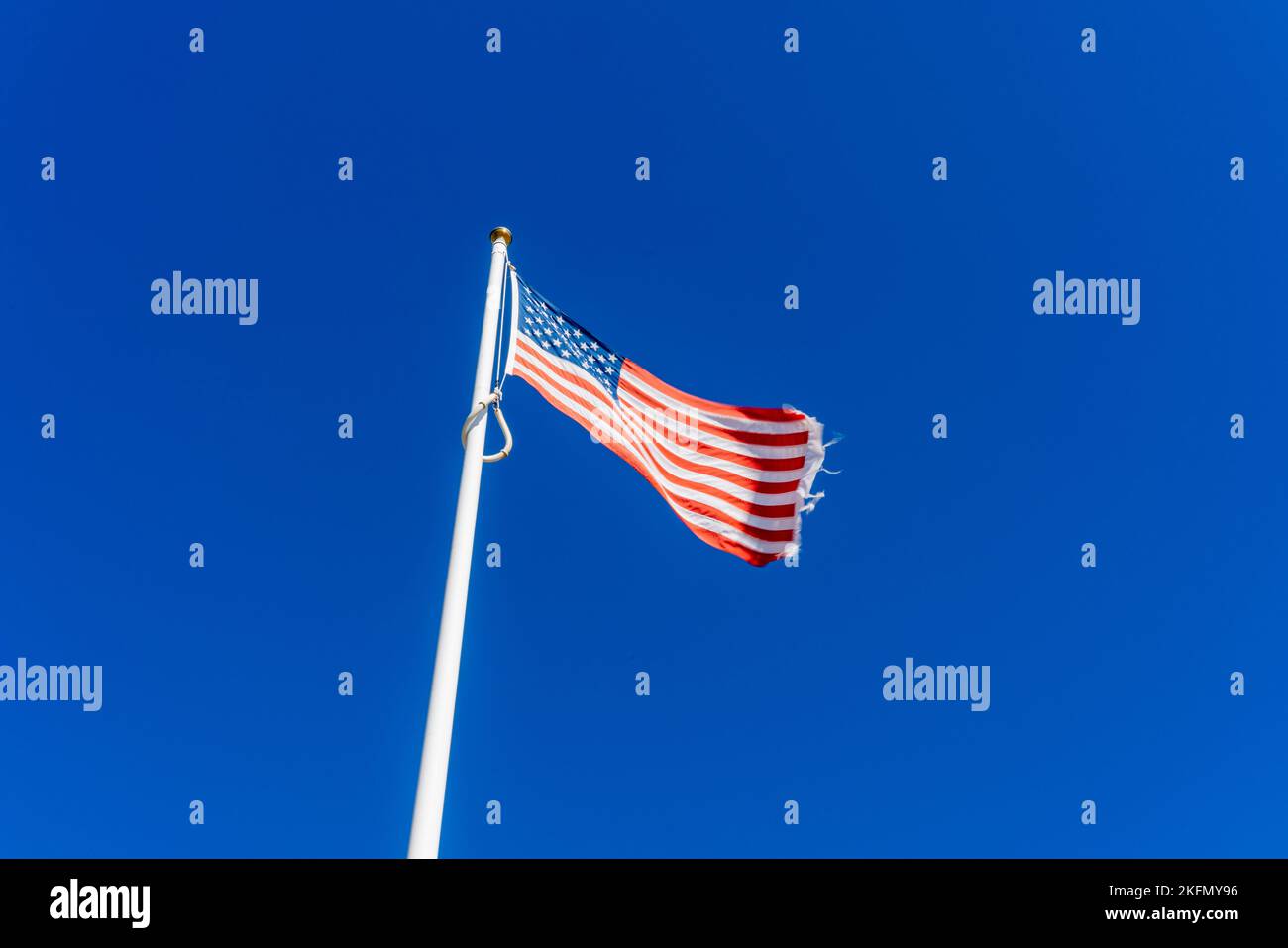 A low angle of an American Flag under a clear blue sky Stock Photo - Alamy