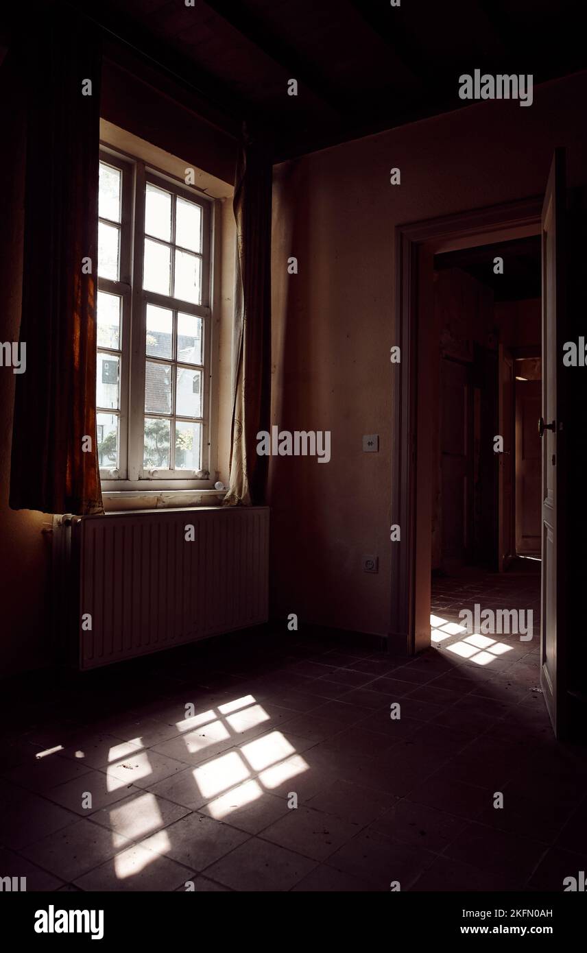 A vertical low-angle of an empty room with a sunlit old window Stock ...