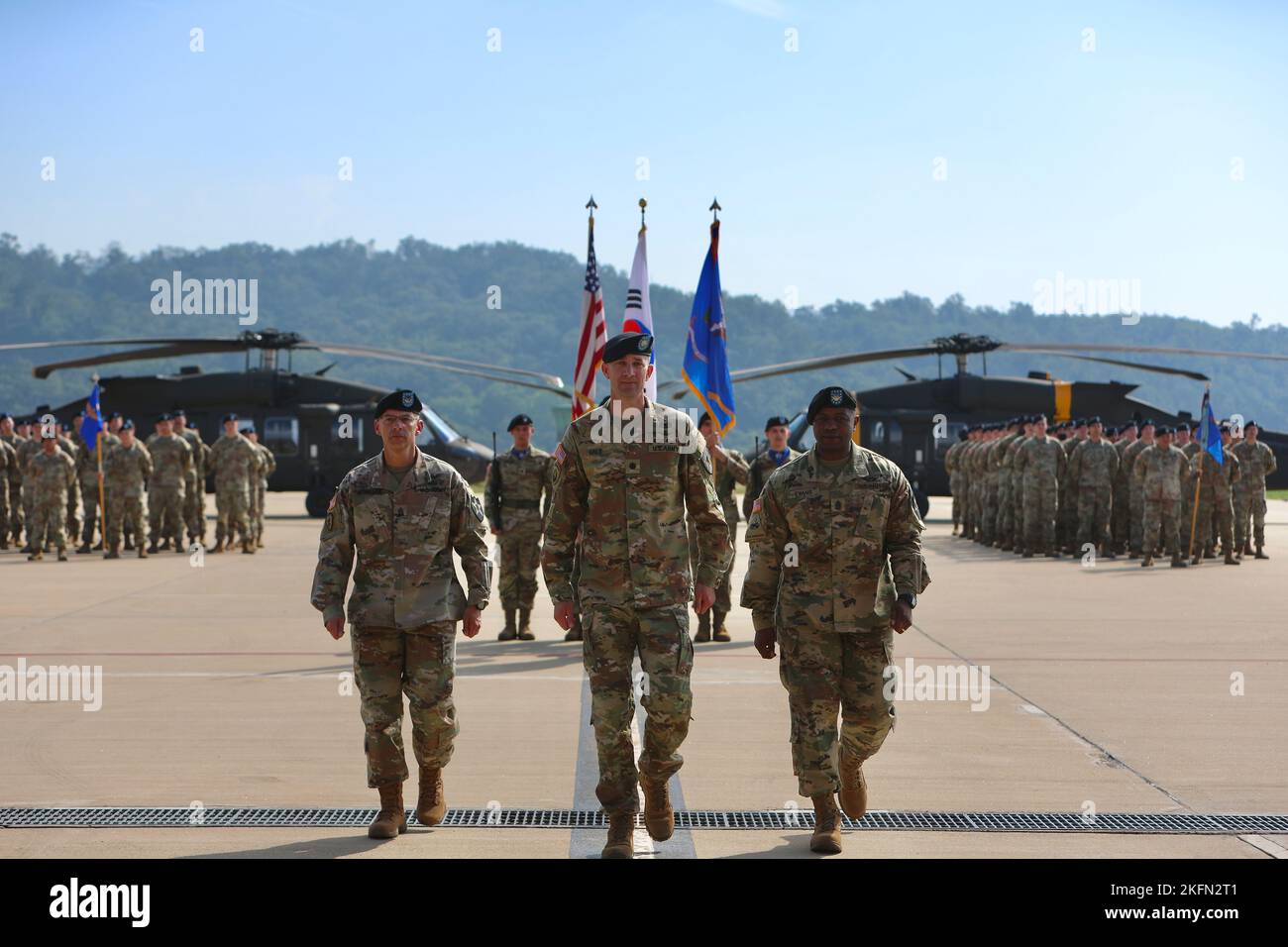 The outgoing and incoming Command Sergeants Major walk with Lt. Col ...