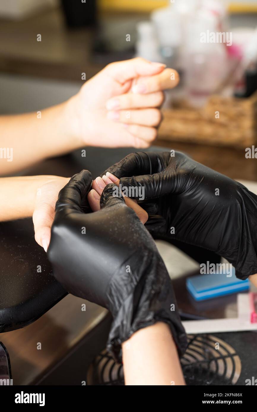 Manicurist work process. The manicure master checks the length of the ...