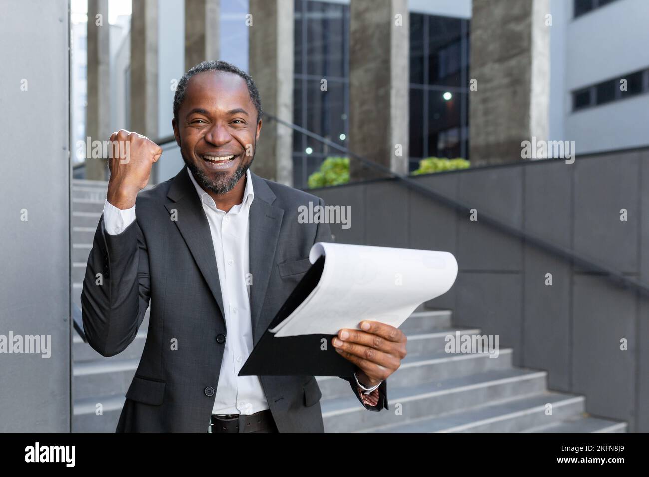Businessman with documents happy and looking at camera, mature african ...