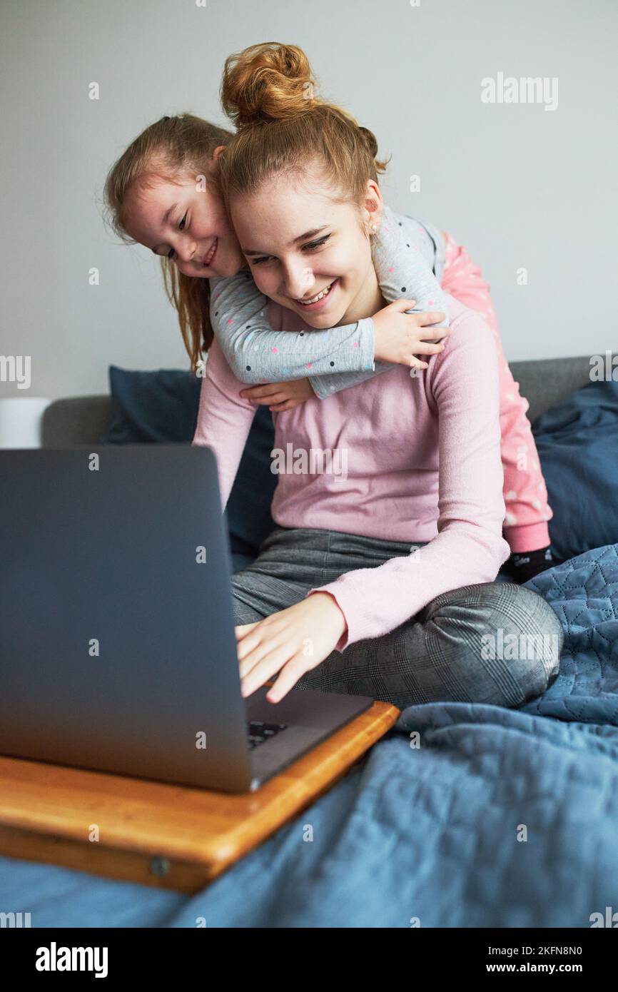Grandchildren teenage girl and her younger sister talking on video call ...