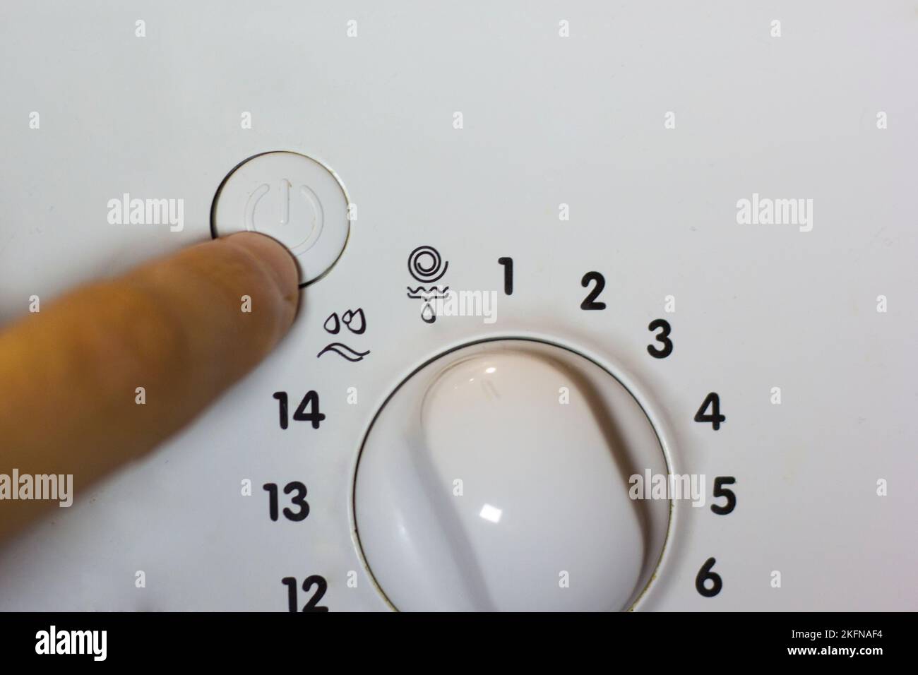 Man's hand presses the start button on the washing machine Stock Photo ...