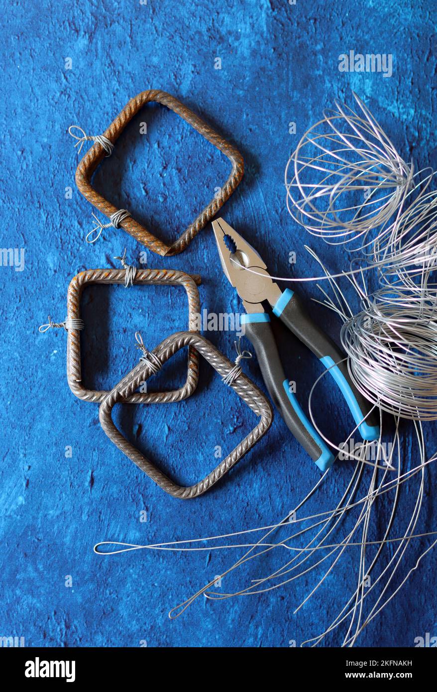 Steel wire and blue pliers close up photo. Craftsman tools on a ...