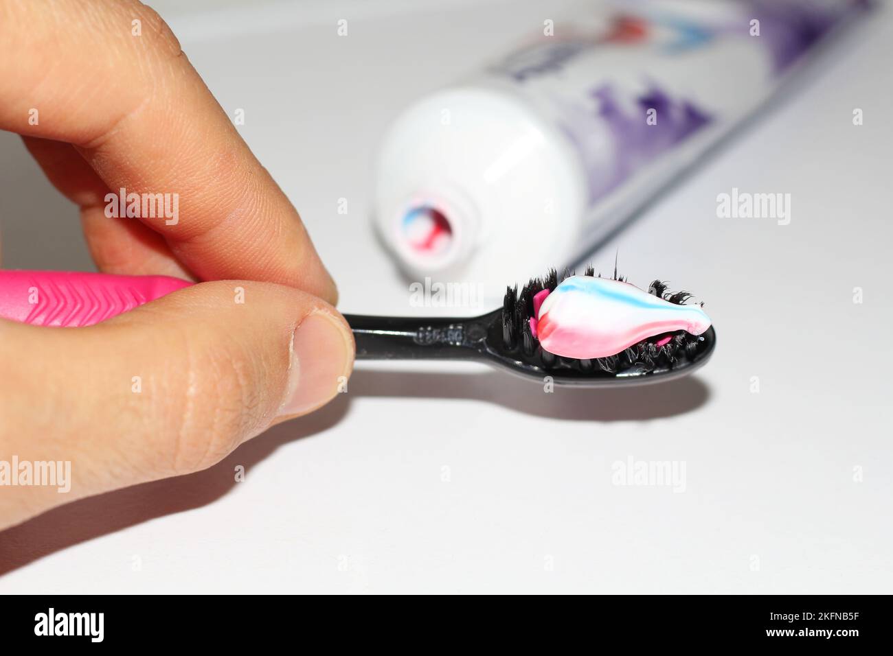 man's hand holding a toothbrush with toothpaste Stock Photo - Alamy