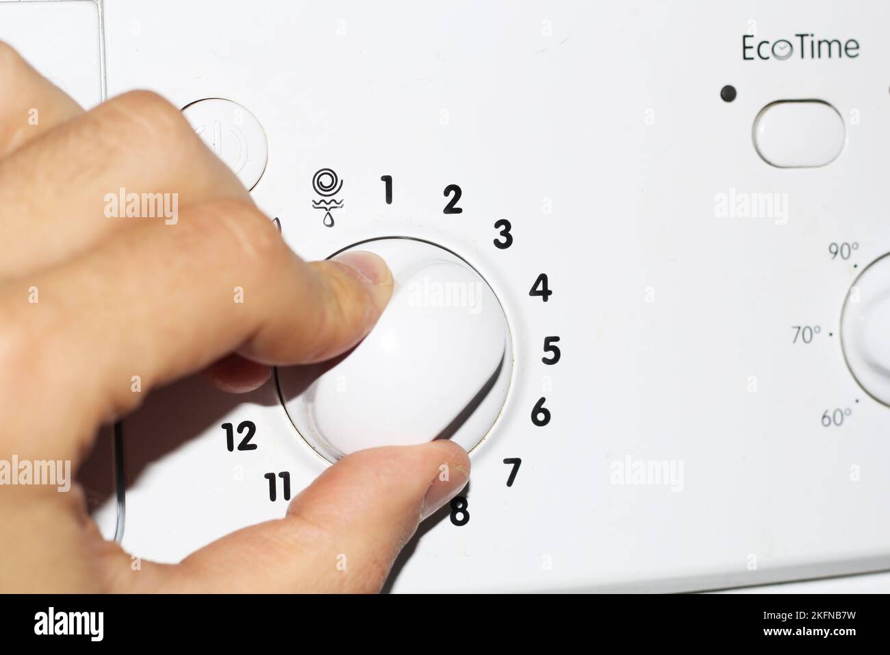 Man's hand presses the buttons on the control panel of the washing ...