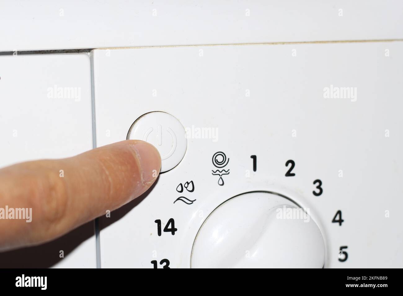 Man's hand presses the buttons on the control panel of the washing ...