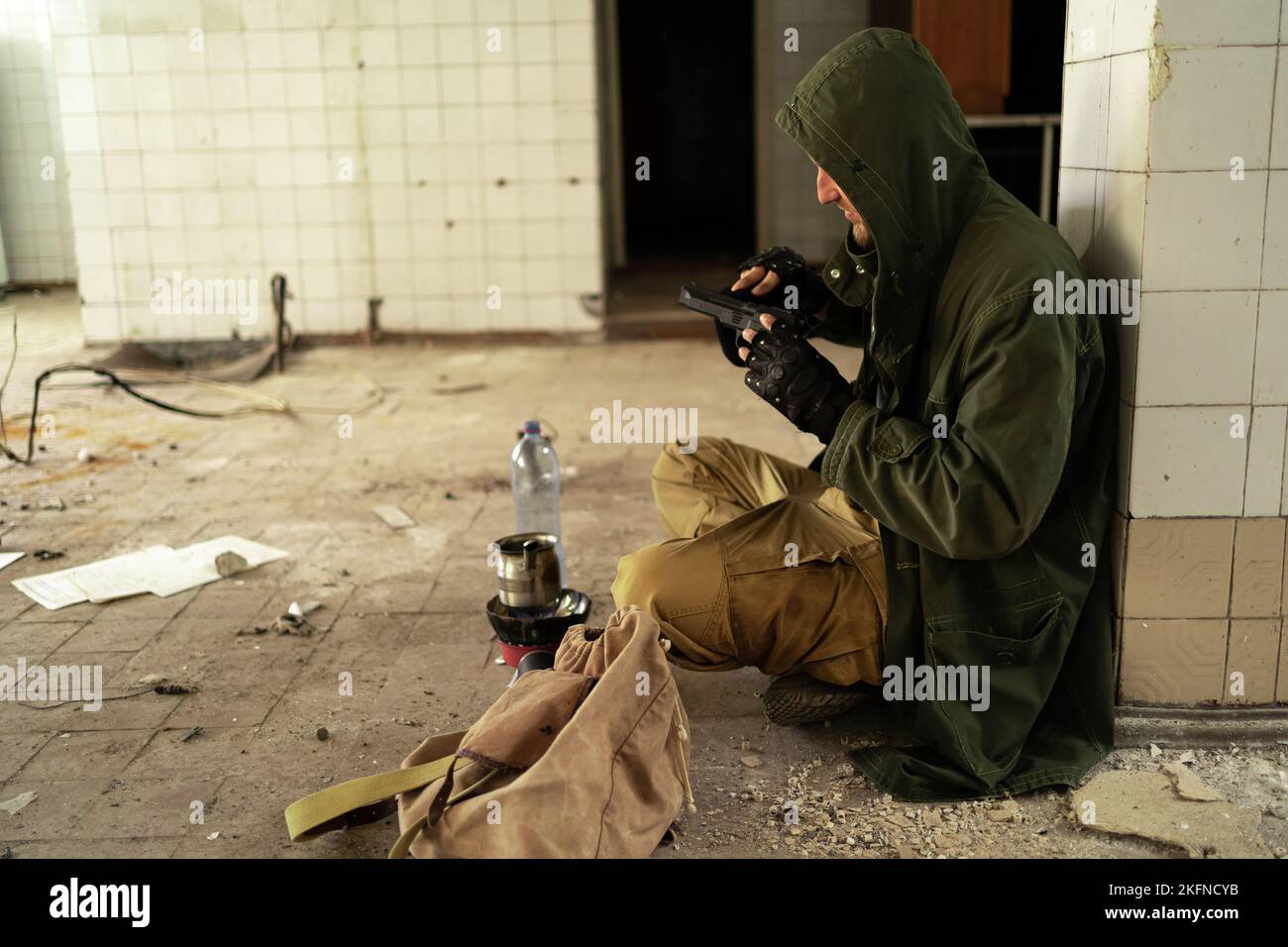 Post apocalypse, survivor, war. A man sitting in an abandoned building ...