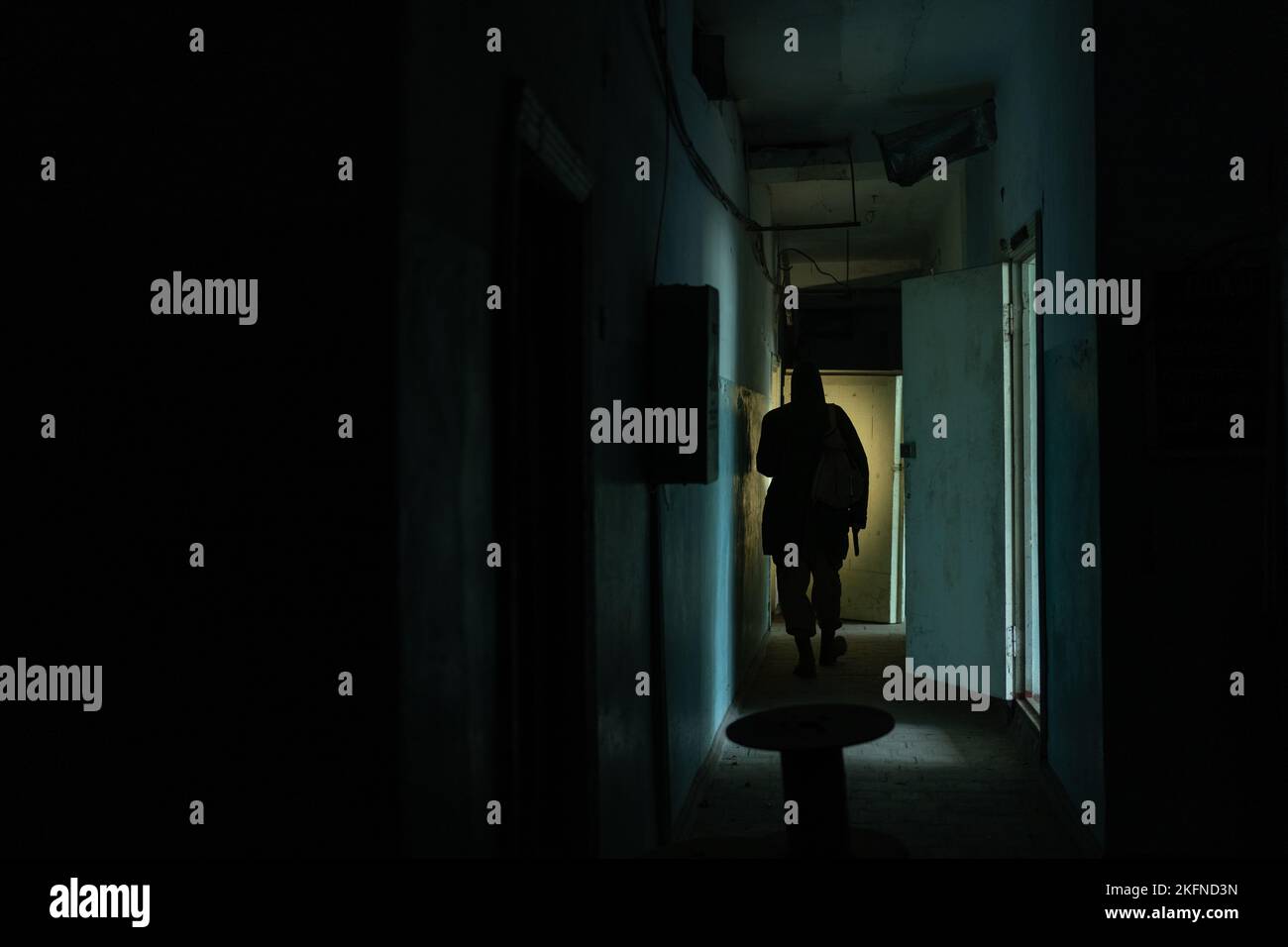 Man explorer with flashlight indoor corridor of ruined industrial ...