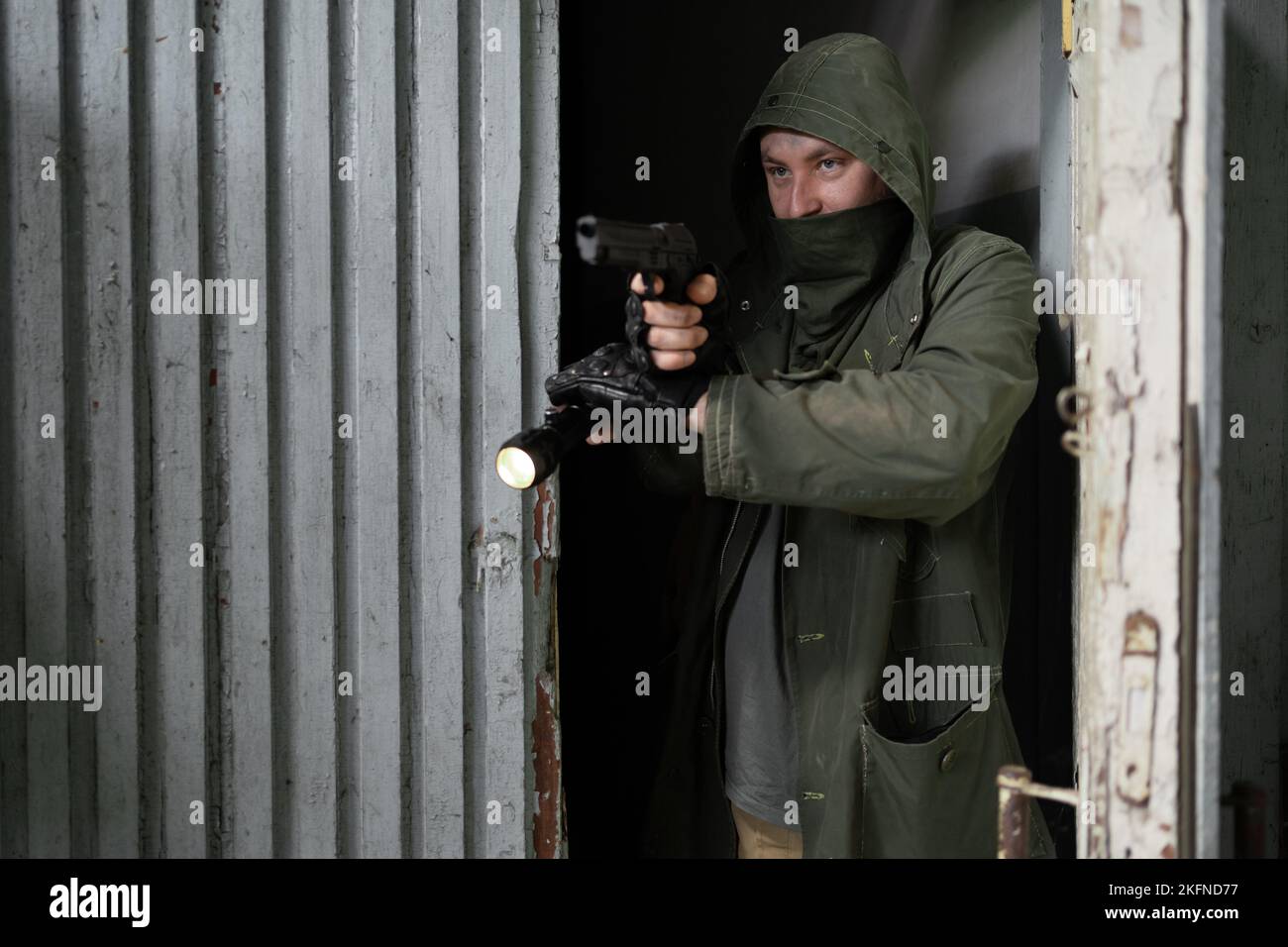 Portrait of a soldier who is aiming at a collimator sight of a gun ...