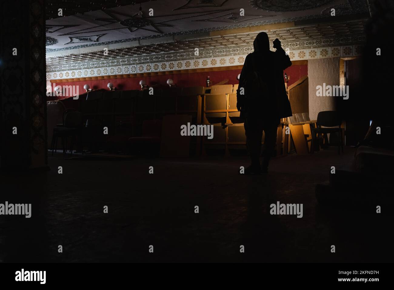 Man in dark abandoned room using flashlight. Guy inspects an abandoned ...