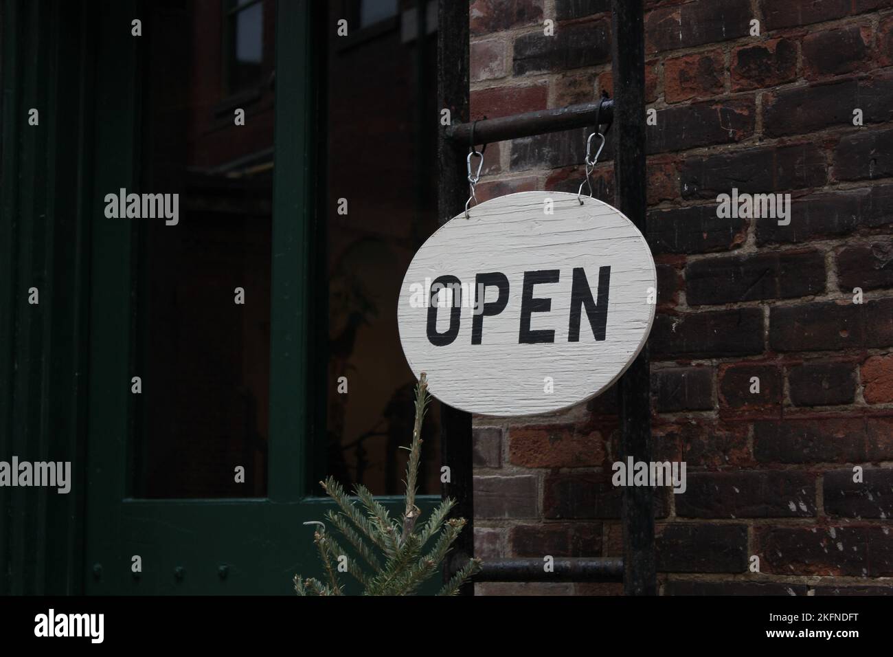 A big circular wooden Open sign hanging in front of a building Stock ...